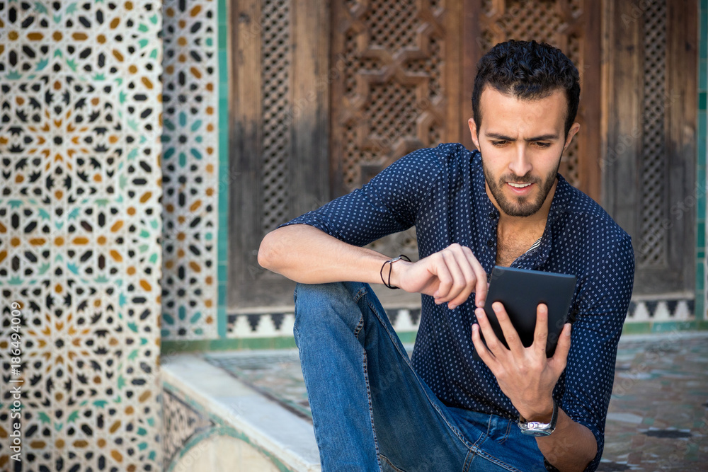 Young Muslim man working on tablet Stock-Foto | Adobe Stock