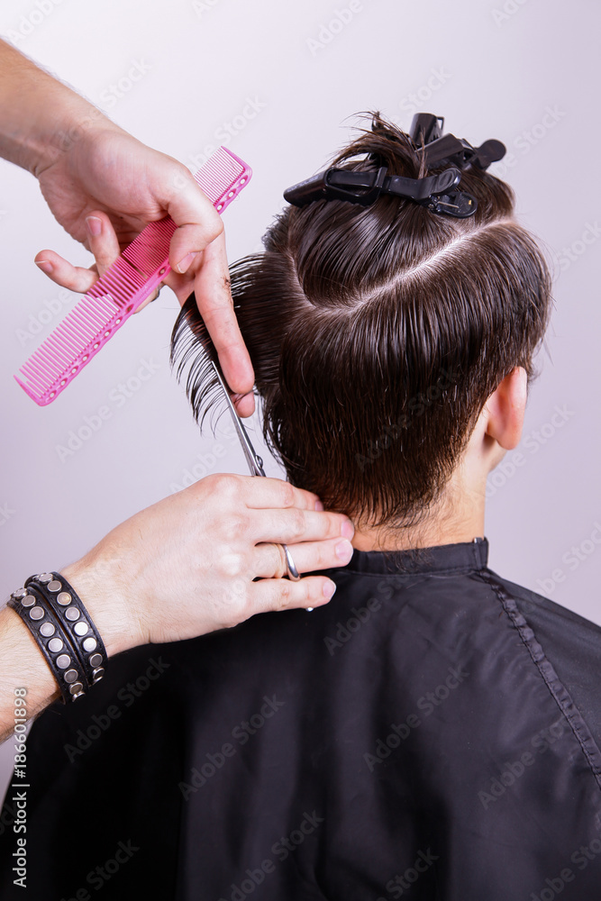 The process of male haircuts. A hairdresser is cutting a guy. Barber ...