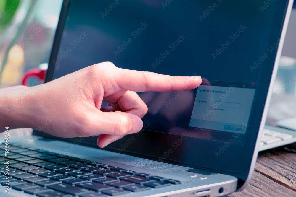 focus on the point figer touching the laptop screen for inputing the ...