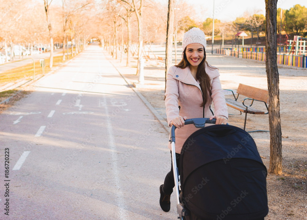 Happy young mother with baby in buggy walking in autumn park Stock ...