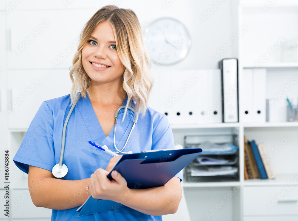 Kindly woman in doctor's uniform greets visitors at modern office Stock ...