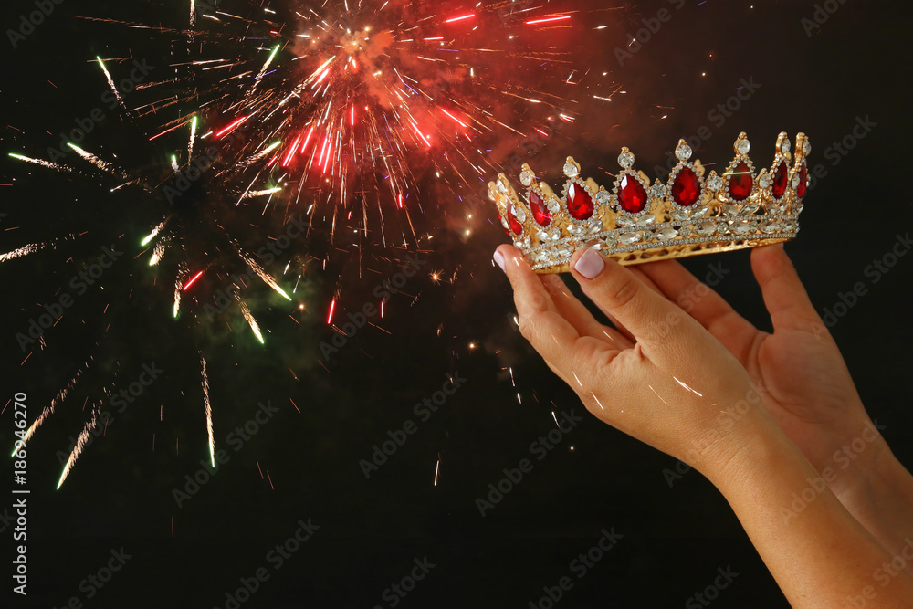 Woman's hand holding a crown for show victory or winning first place ...