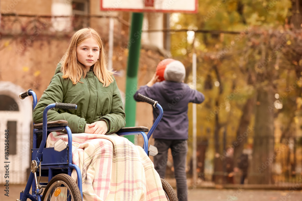 Sad little girl in wheelchair on playground Stock Photo | Adobe Stock