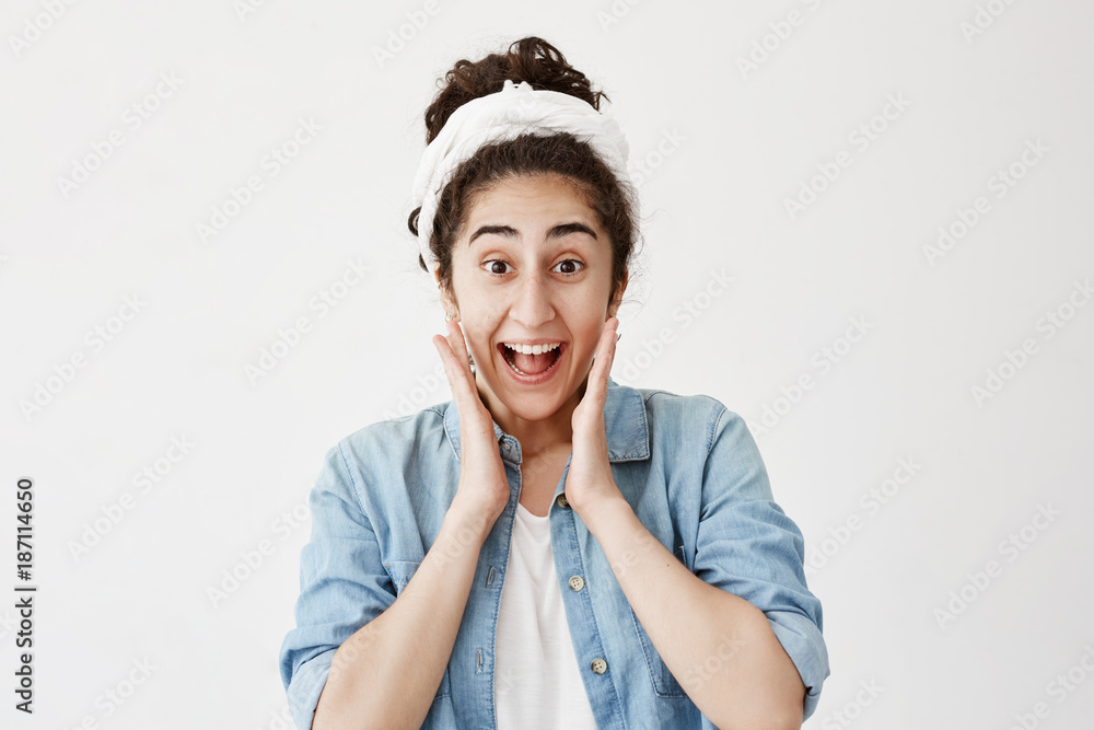 Happy excited female has dark hair, wearing do-rag and denim shirt ...