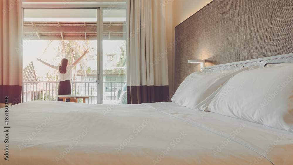 Asian women are staying in a hotel room. Open the curtain in the room ...