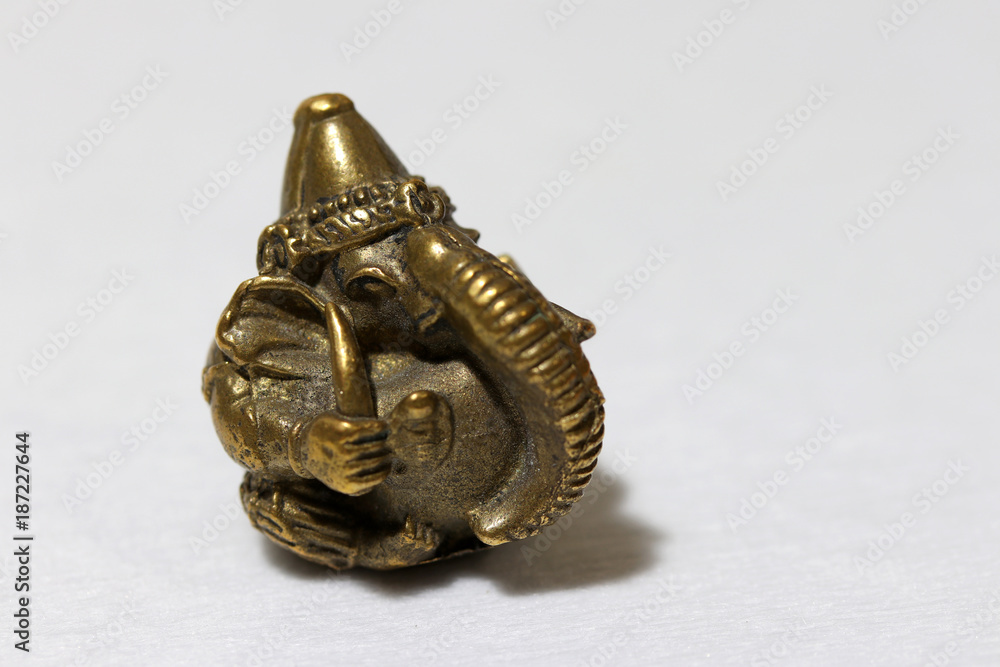 Mini Ganesha made from brass on white background, the son of Uma Devi ...