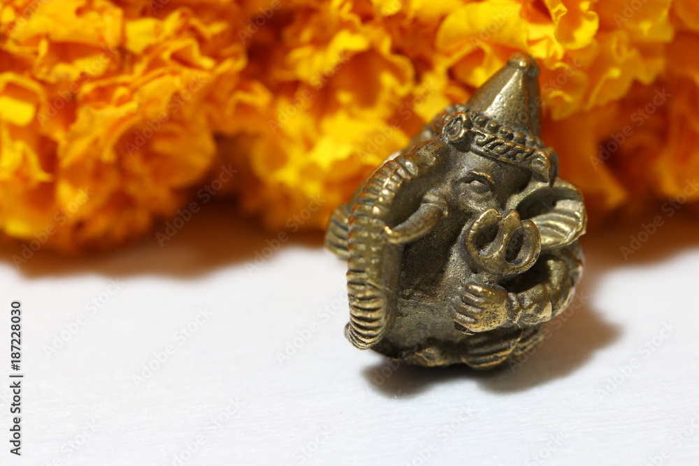 Mini Ganesha made from brass with yellow marigold flower and white ...
