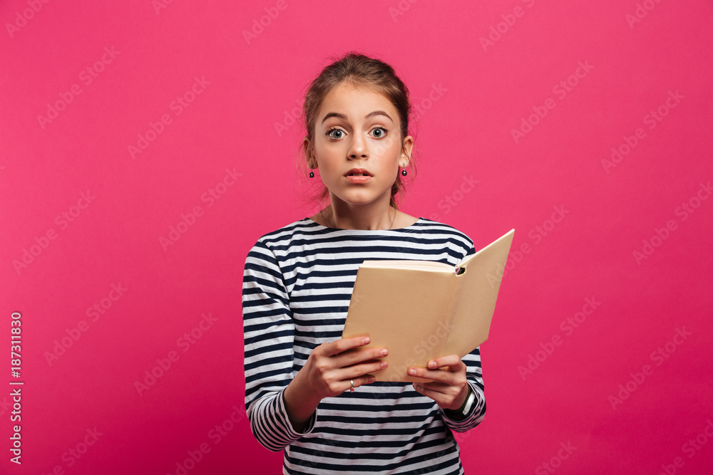 Teenage shocked girl holding book. Stock Photo | Adobe Stock