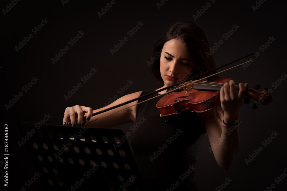 Beautiful young woman playing a violin over black background Stock ...
