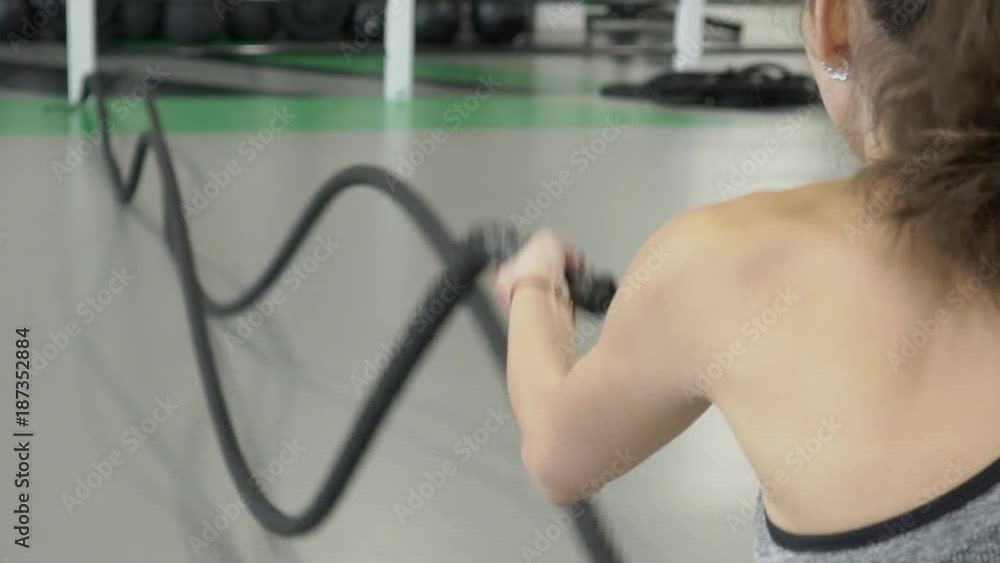 Vidéo Stock Young woman doing exercise with rope in sports club. Female ...