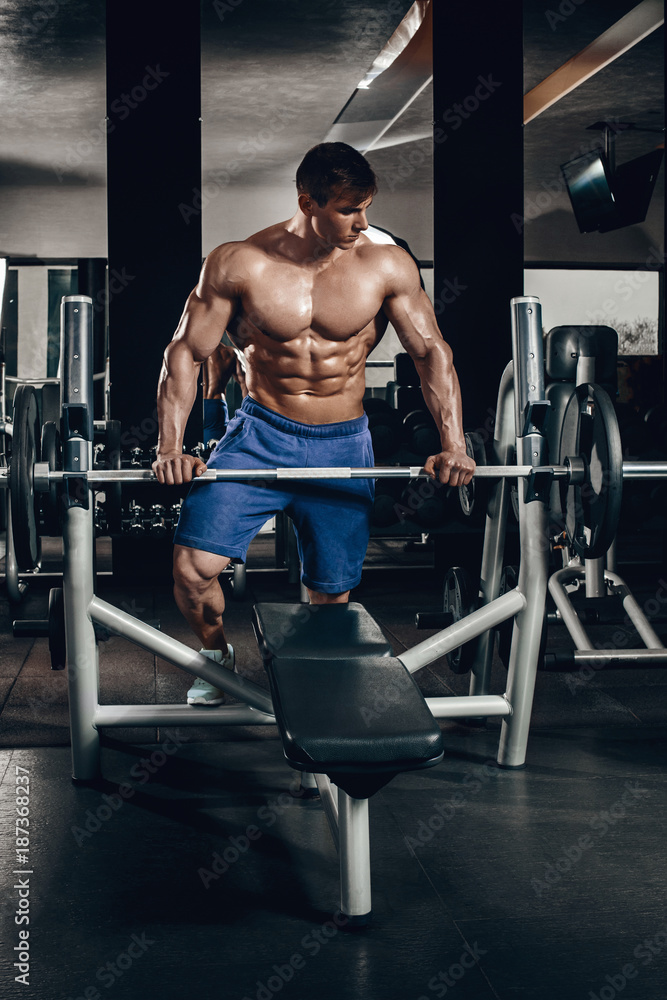 Handsome power athletic man on diet training pumping up muscles with ...