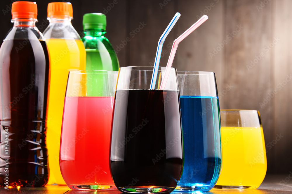 Glasses and bottles of assorted carbonated soft drinks Photos | Adobe Stock