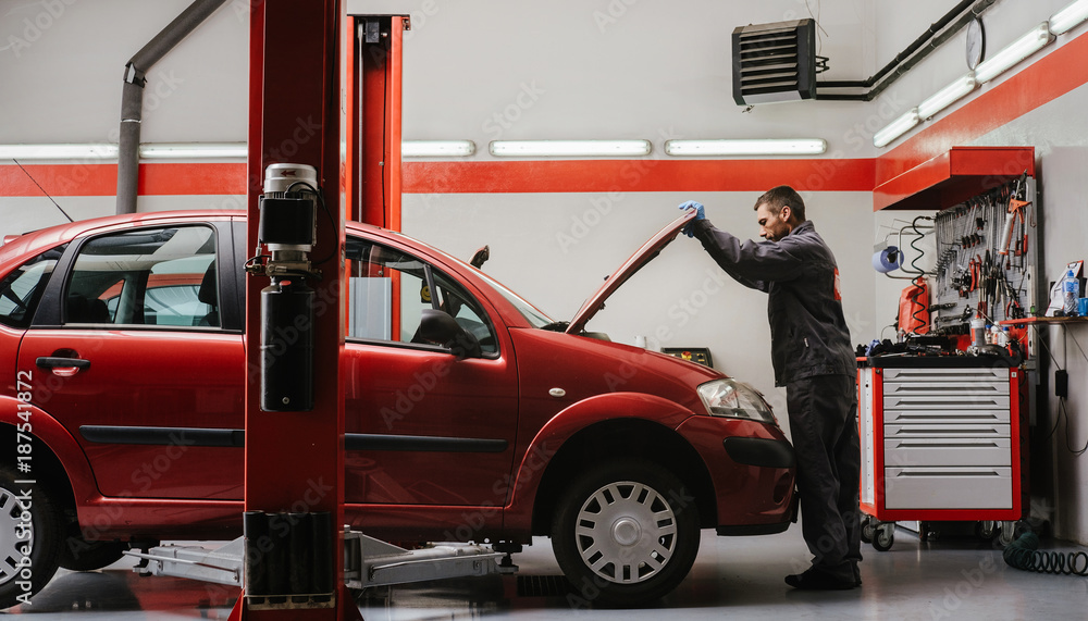 Mechanic working on car in garage/workshop Stock Photo | Adobe Stock