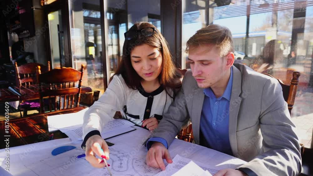 Boy helping girlfriend with architect home task drafting at cafe table. Stock-Video | Adobe Stock