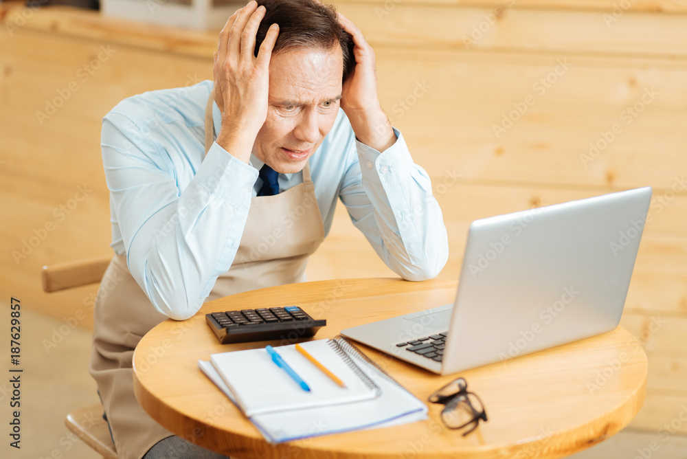 Bad situation: Sad disappointed senior entrepreneur sitting opposite ...