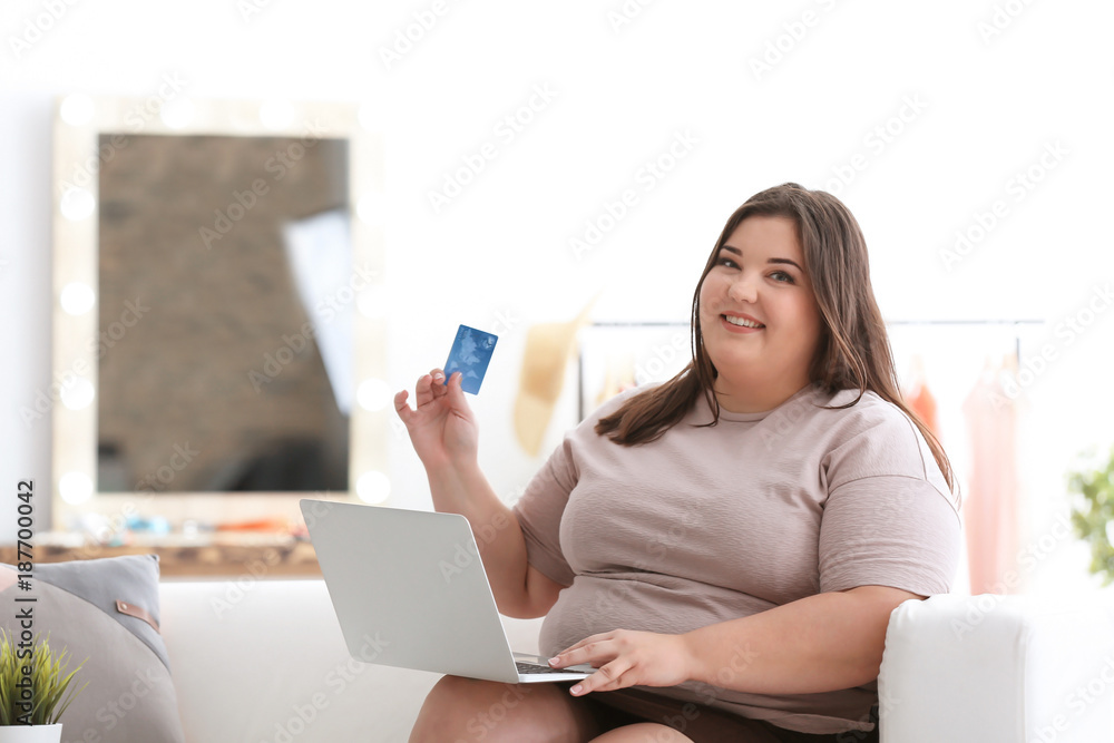 Beautiful overweight woman with laptop and credit card indoors Stock ...