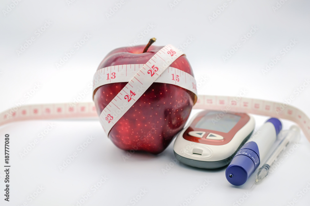 A fresh red apple with tape measure with Glucose meter, lancet and ...