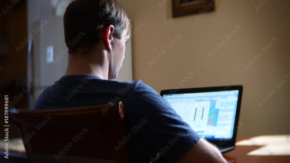 A man sitting at home at the kitchen table, watching changes in the ...