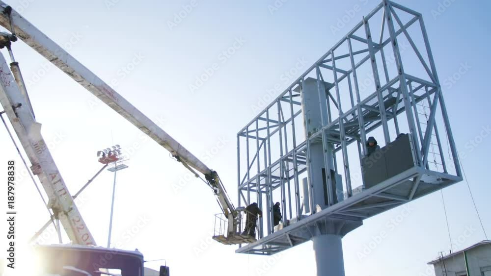 Builder on a Lift Platform at a construction site. Men at work ...