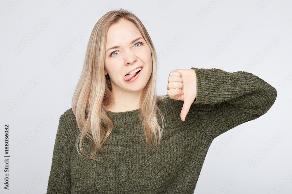 European woman shows disapproval sign, gives thumb down gesture ...