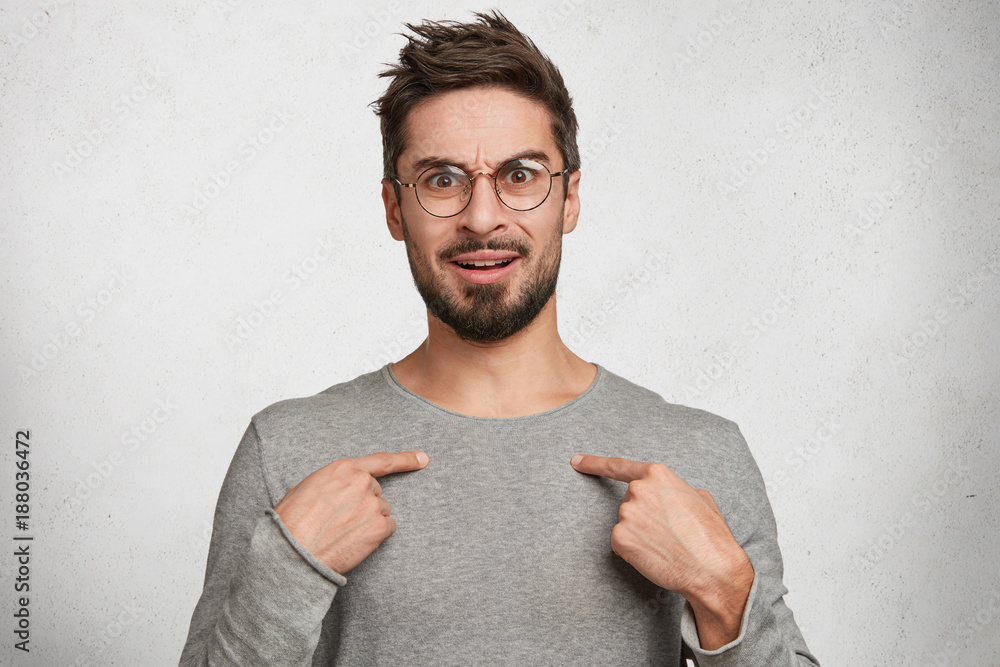 Indignant young male with trendy hairdo, dark mustache and beard points ...