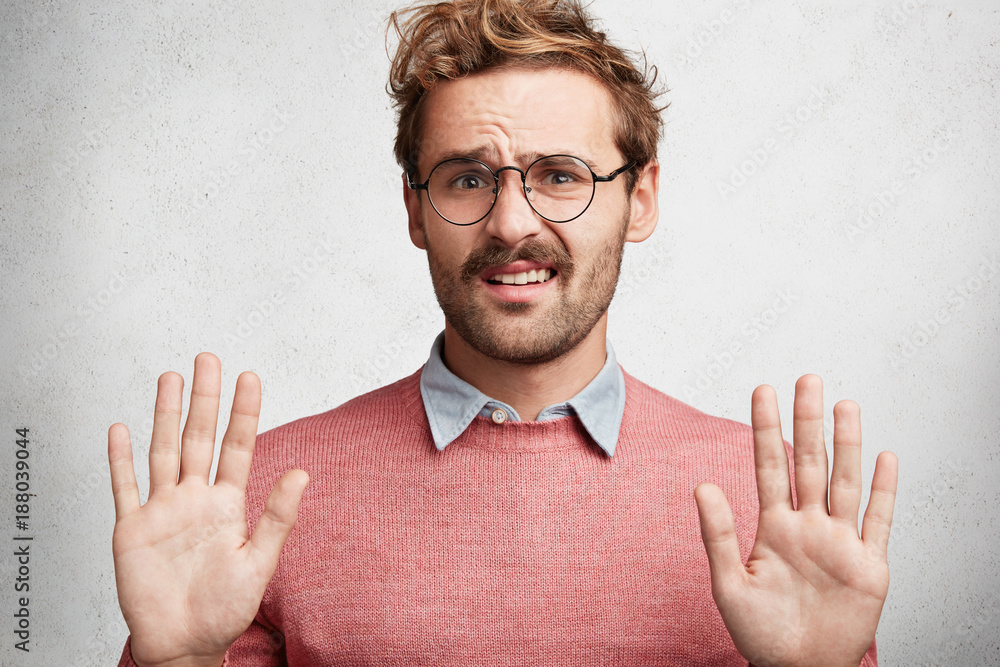 Handsome young male refuses offer, gestures indoor, shows his ...