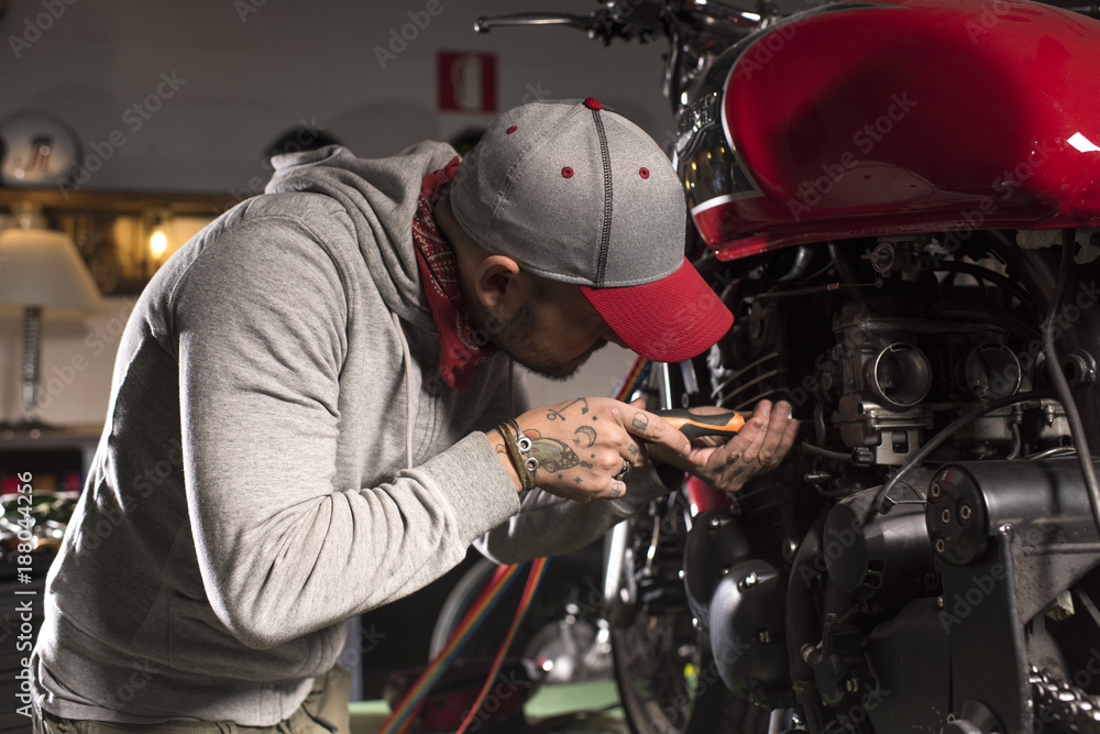 Motorbike mechanic repairing a motorbike Stock-Foto | Adobe Stock