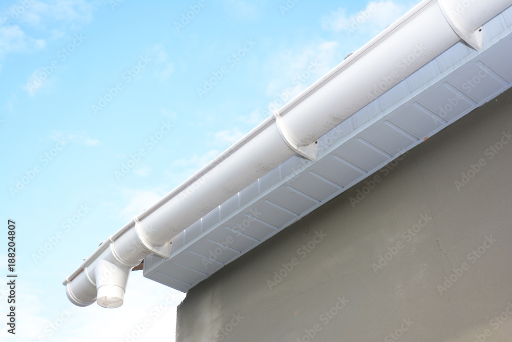 Roof gutter repair. Rain gutter installation with drain downspout pipe ...