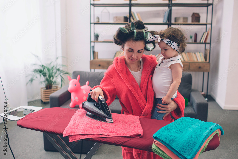 mother and baby together engaged in housework Ironing clothes ...