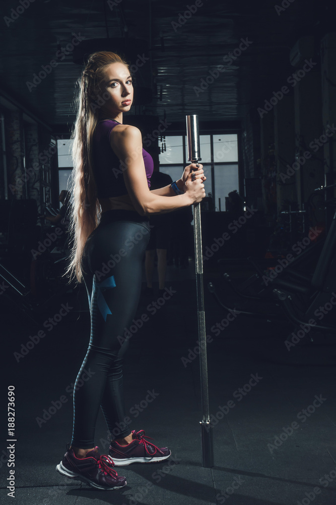 Close-up portrait of muscular young girl training with barbells in the ...