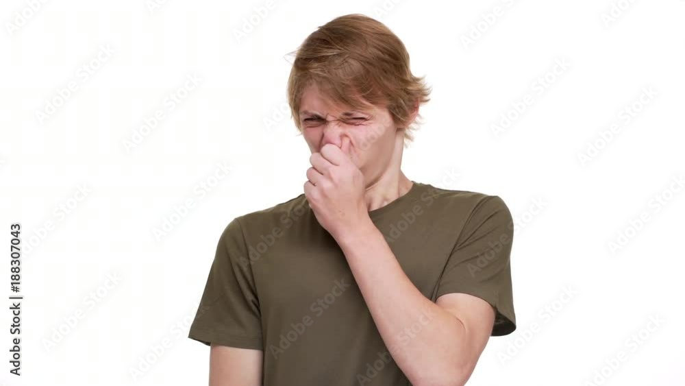 Portrait of man pinching nose with disgust on his face due to bad smell ...