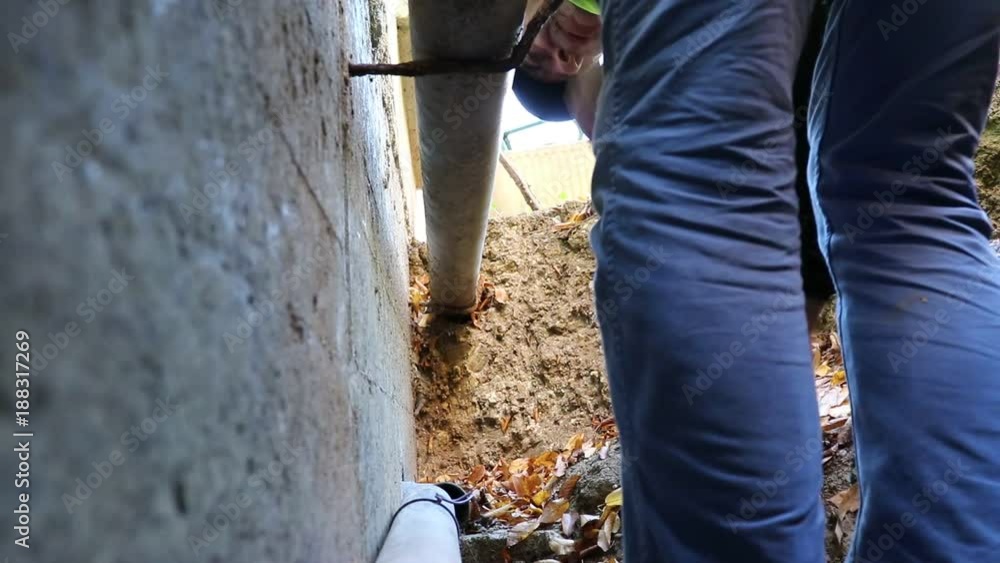 Stockvideon A man conducts plumbing in difficult conditions in a narrow ...
