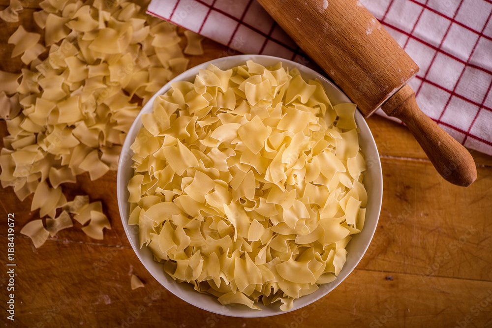 dry square pasta shapes in white bowl plate on wood table Stock Photo ...