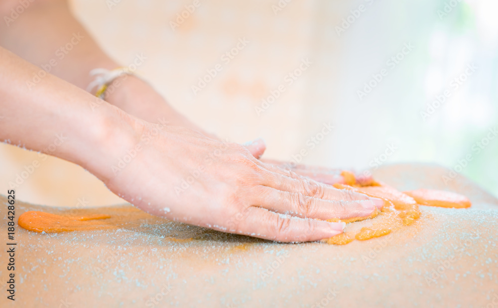 Therapist hand is Applying orange spa salt scrub on a woman back Stock ...