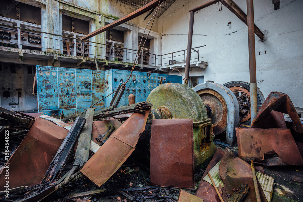 Ruined abandoned hydroelectric power plant. Rusty generator at ...