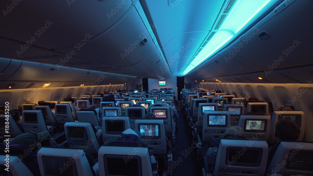 Interior passengers airplane with people on seats. Aircraft cabin with ...