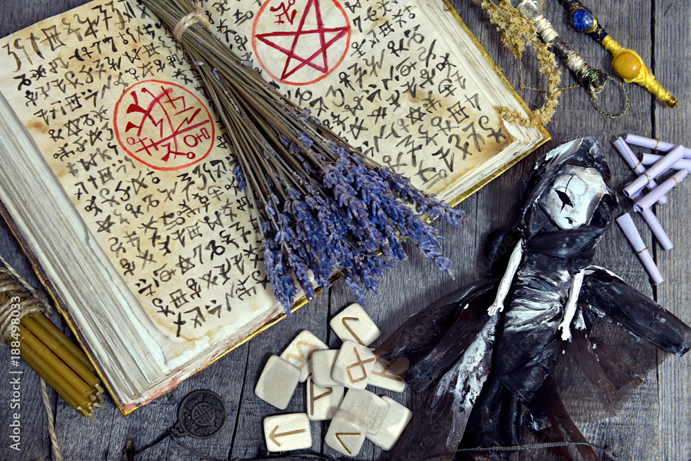 Witch book with magic symbols, lavender bunch, scary doll and runes on ...