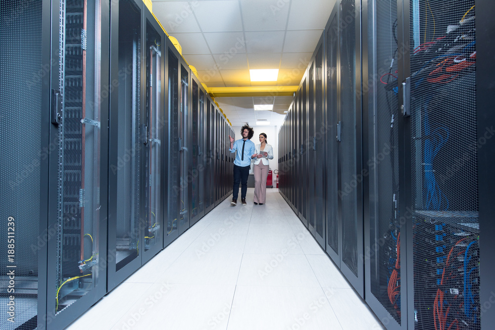 engineer showing working data center server room to female chief Stock ...