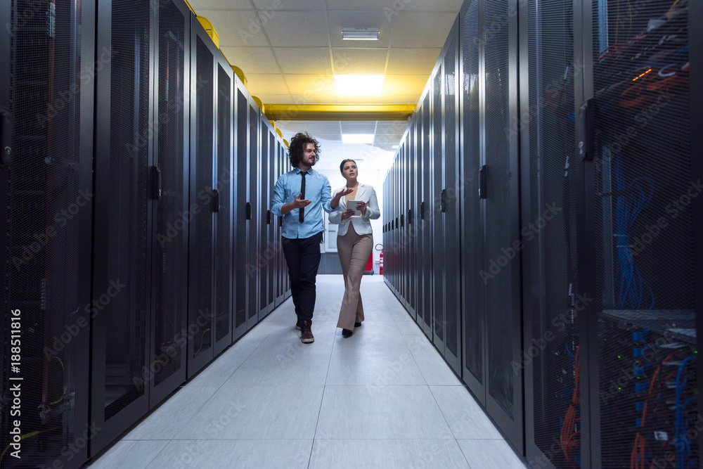 engineer showing working data center server room to female chief Stock ...