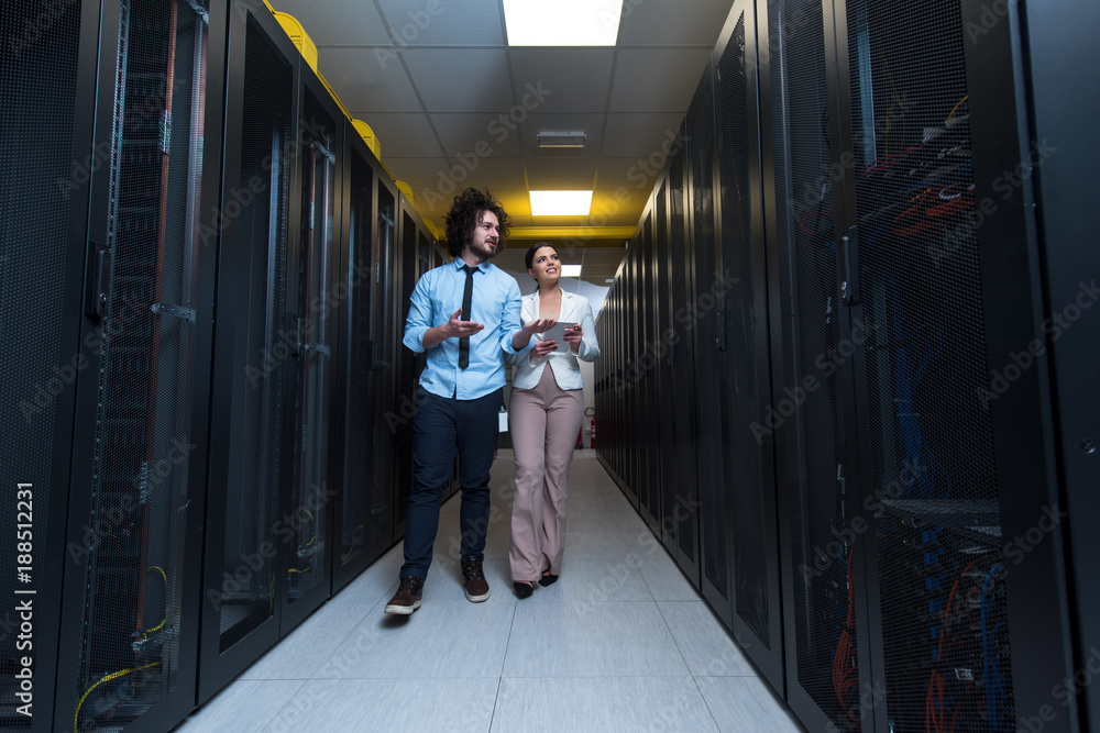 engineer showing working data center server room to female chief Stock ...