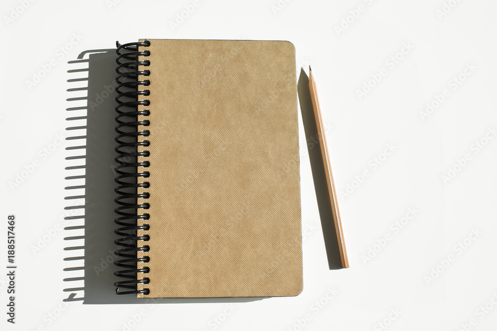 Spiral light brown notebook beside pencil on white background Stock ...