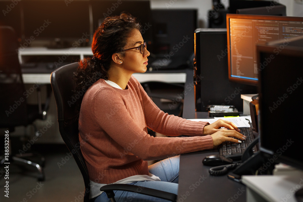 Female programmer working on new project.She working late at night in ...