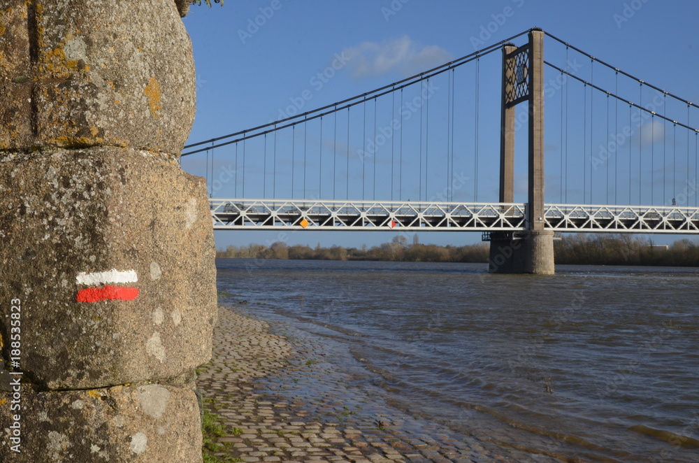 Balise de Grande randonnée devant le pont suspendu Bretagne-Anjou à ...