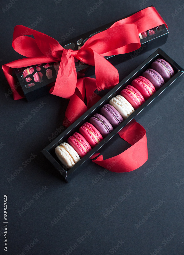 macaroon on black background with red ribbon, colorful almond cookies ...
