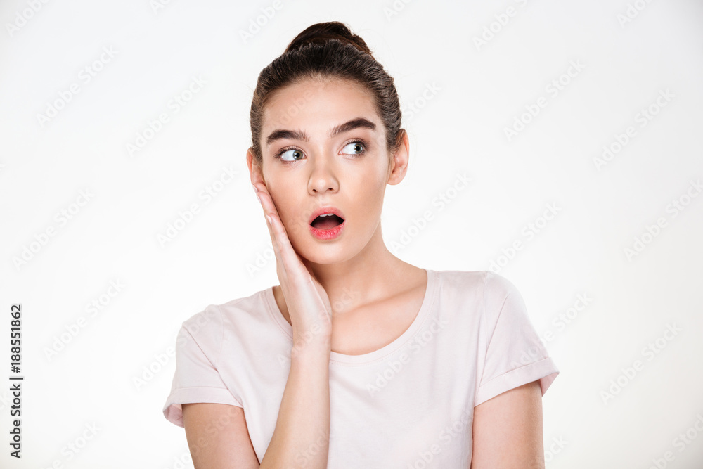 Pretty woman with brown hair in bun touching her face expressing ...