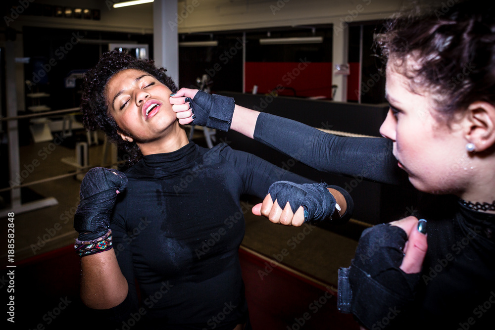 Tough female fighter punching her opponent in the face while practicing ...