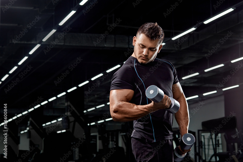 Muscular bodybuilder doing exercises with dumbbell in gym.Strong ...