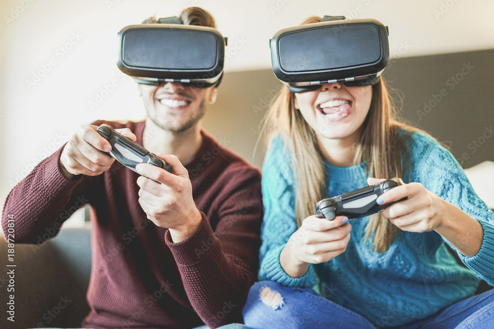 Young happy friends playing video games wearing virtual reality glasses ...