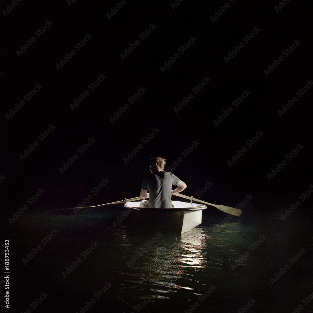 Man in boat lost at sea Stock Photo | Adobe Stock