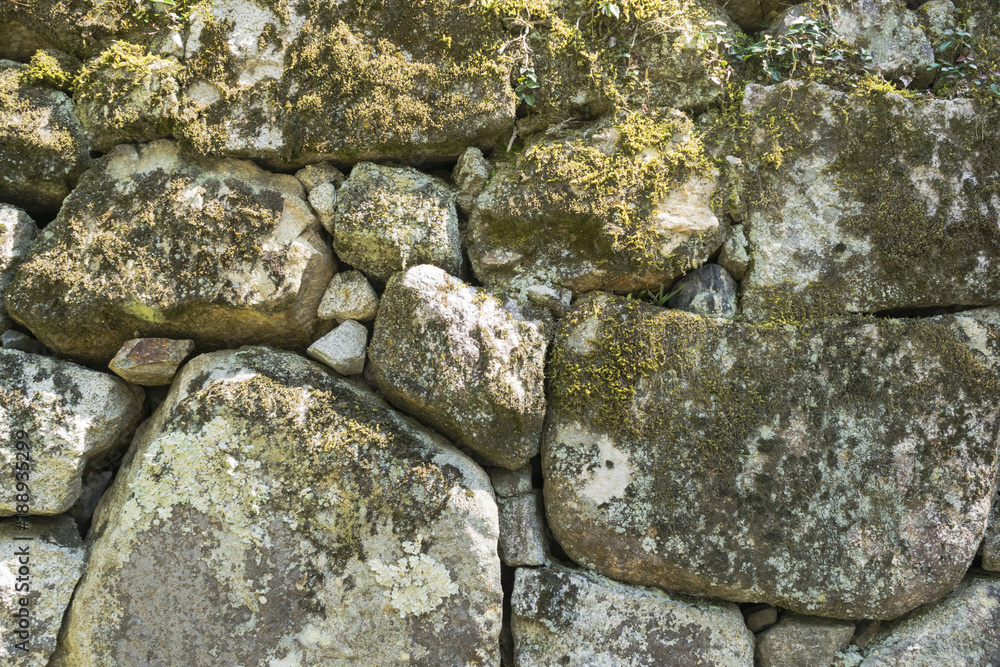Stone wall background texture with green moss in traditional Japanese ...